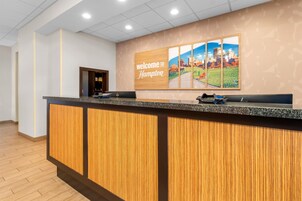 Bancada de recepção com um mural de paisagem urbana, design em painel de madeira e interior moderno e minimalista.