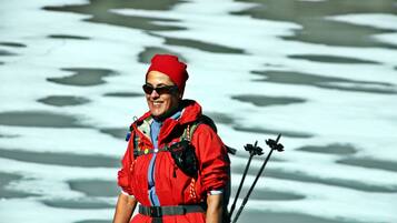 Uma pessoa com casaco e gorro vermelho em cima do gelo.