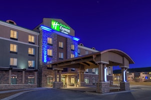 Um hotel Holiday Inn Express com fachada moderna, vários acessos e área de entrada coberta.