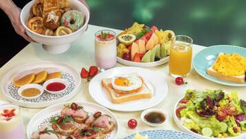 Diversos pratos de pequeno-almoço, incluindo panquecas, ovos e fruta.