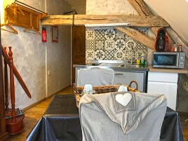 Cozinha compacta com micro-ondas, pia e armários de madeira.