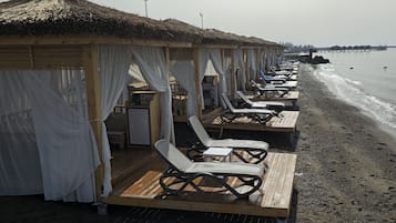 Uma praia privada, espreguiçadeiras, guarda-sóis de praia