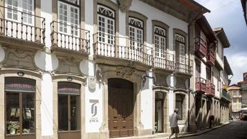 Um edifício histórico com entrada imponente, várias janelas e varandas.