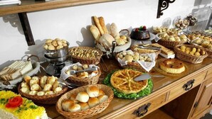 Uma mesa de buffet com diversos pães e doces.