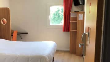 Quarto de hotel com cama, janela com cortinas, televisão e guarda-roupa de madeira.