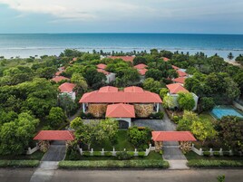 Um resort com vários edifícios, piscina e vista para o mar.