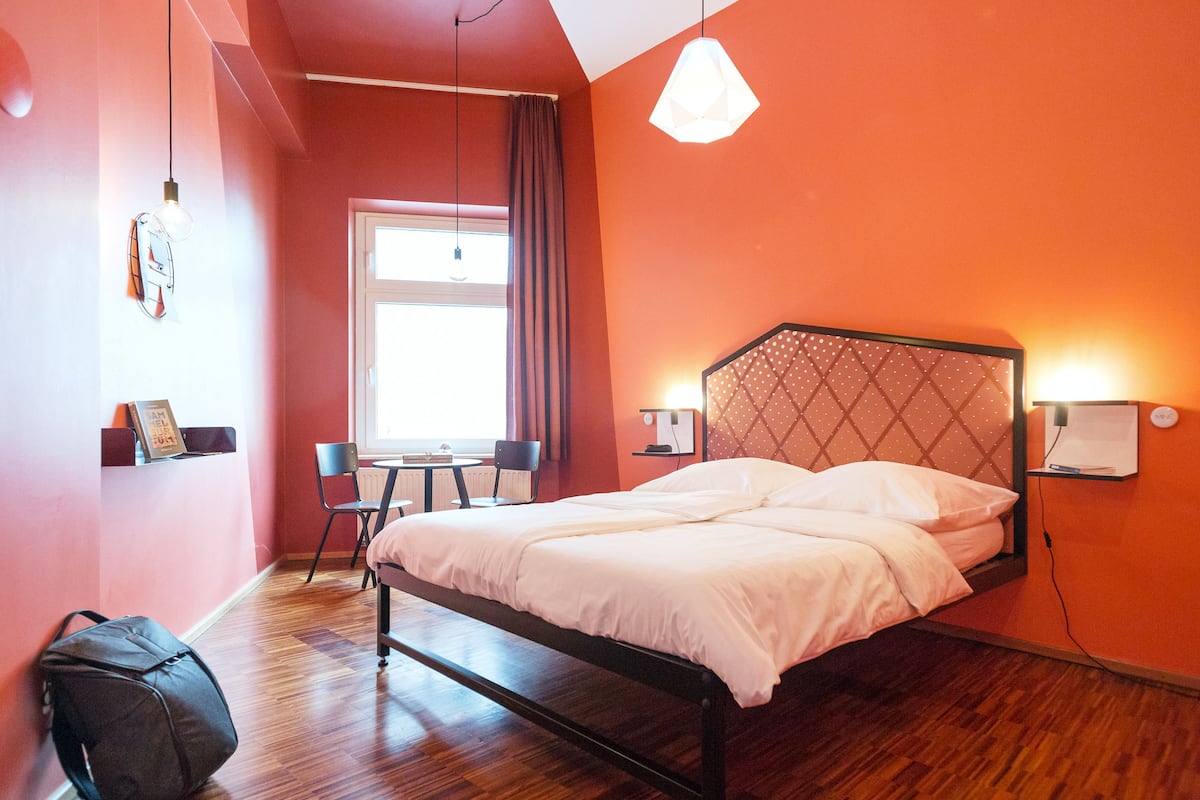 Quarto com cama, escrivaninha e cadeira.