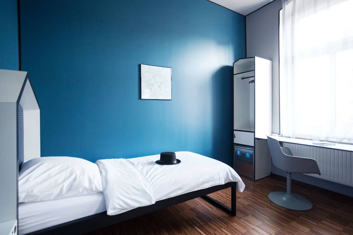 Quarto moderno com cama, escrivaninha e cadeira.