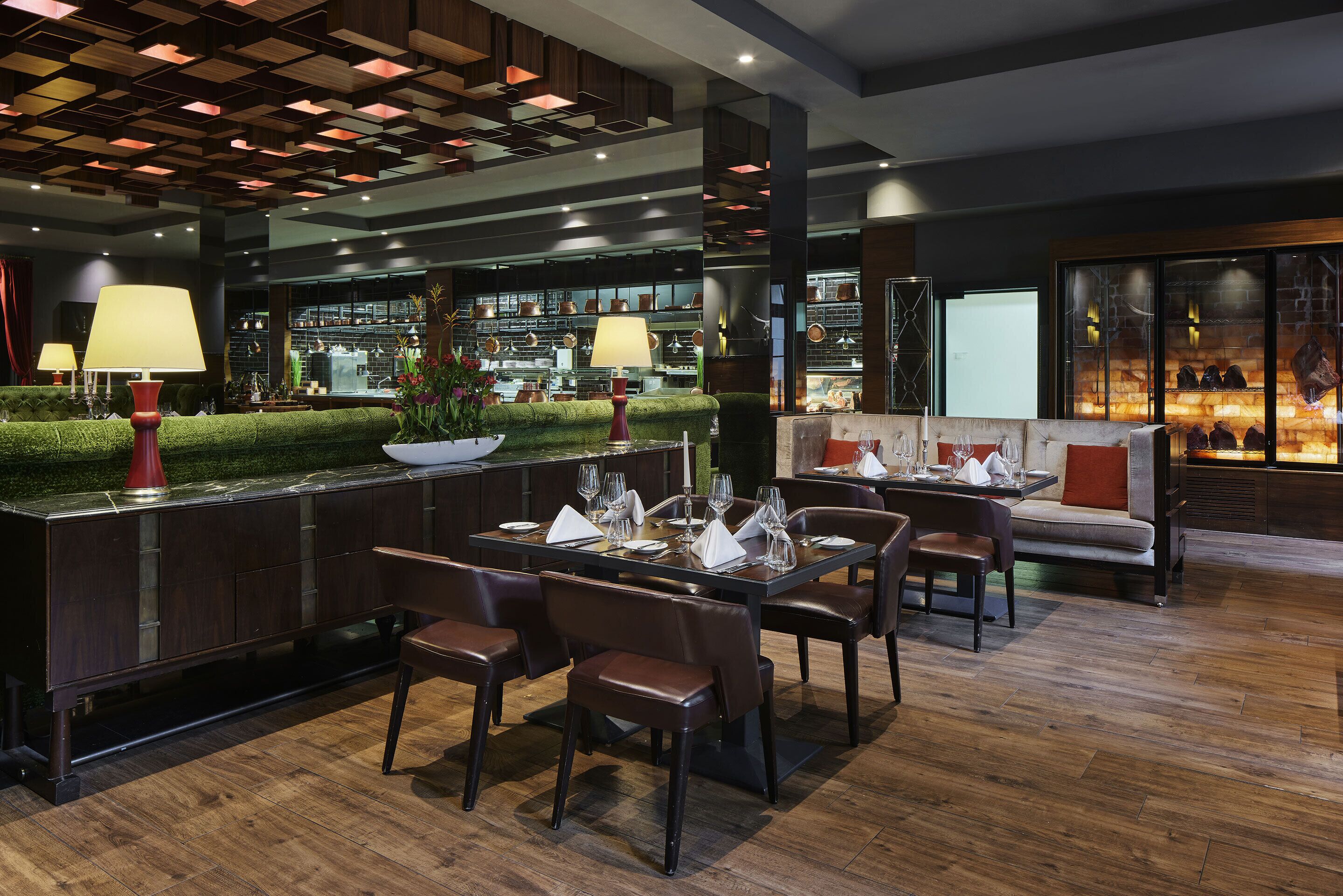 Um restaurante moderno com uma mesa de jantar central, várias cadeiras e um espaço de bar com banquetas.
