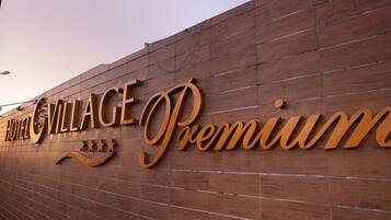 Pared de madeira com o texto 'Hotel Village Premium' e estrelas decorativas.