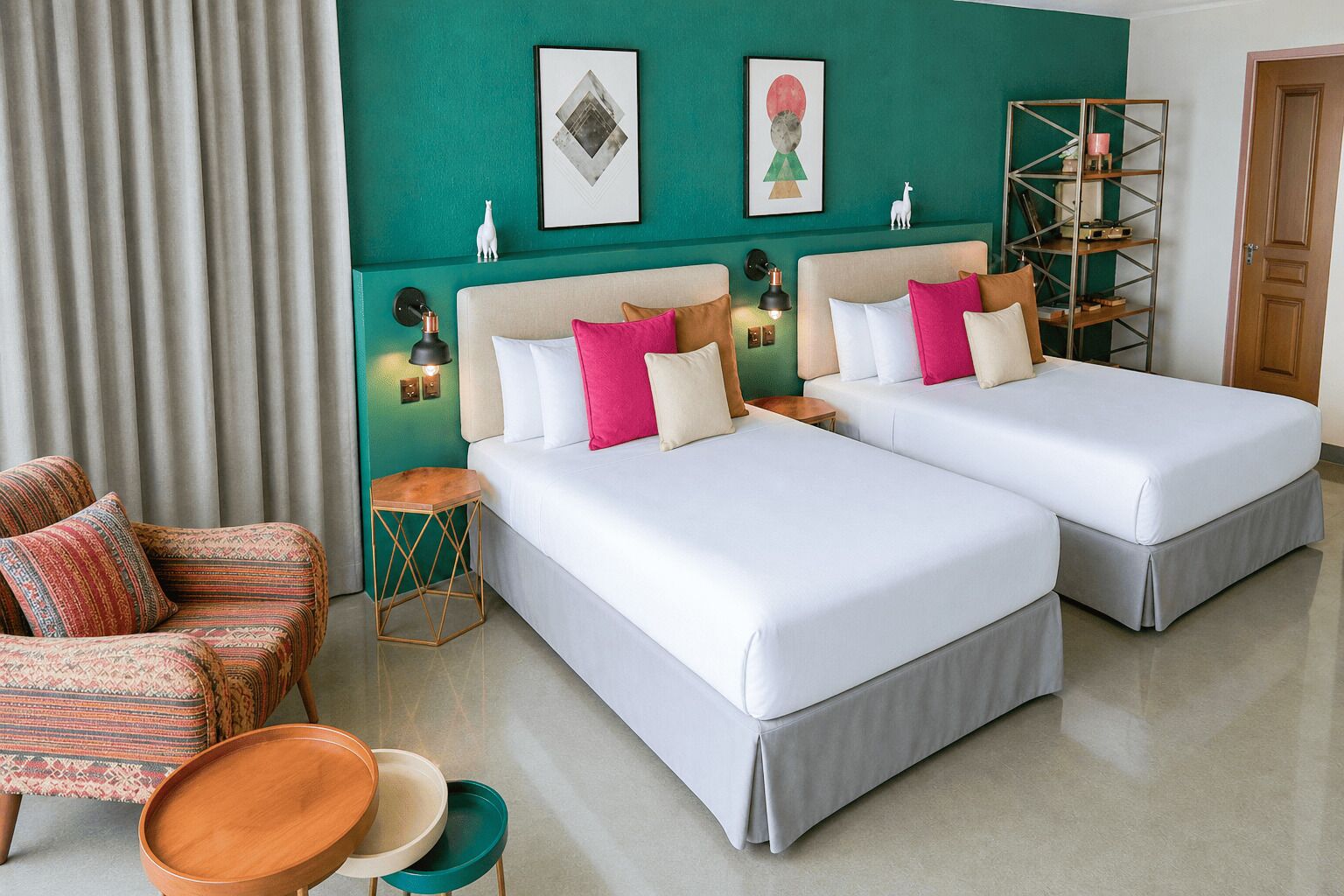 Quarto de hotel com duas camas, um sofá, uma mesinha e uma estante decorativa.
