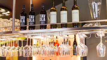 Uma adega com garrafas e copos de vinho.