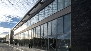 Um edifício moderno com grandes janelas de vidro refletindo o céu.