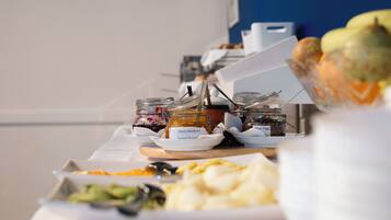 Uma mesa de buffet com diversos alimentos e acompanhamentos.