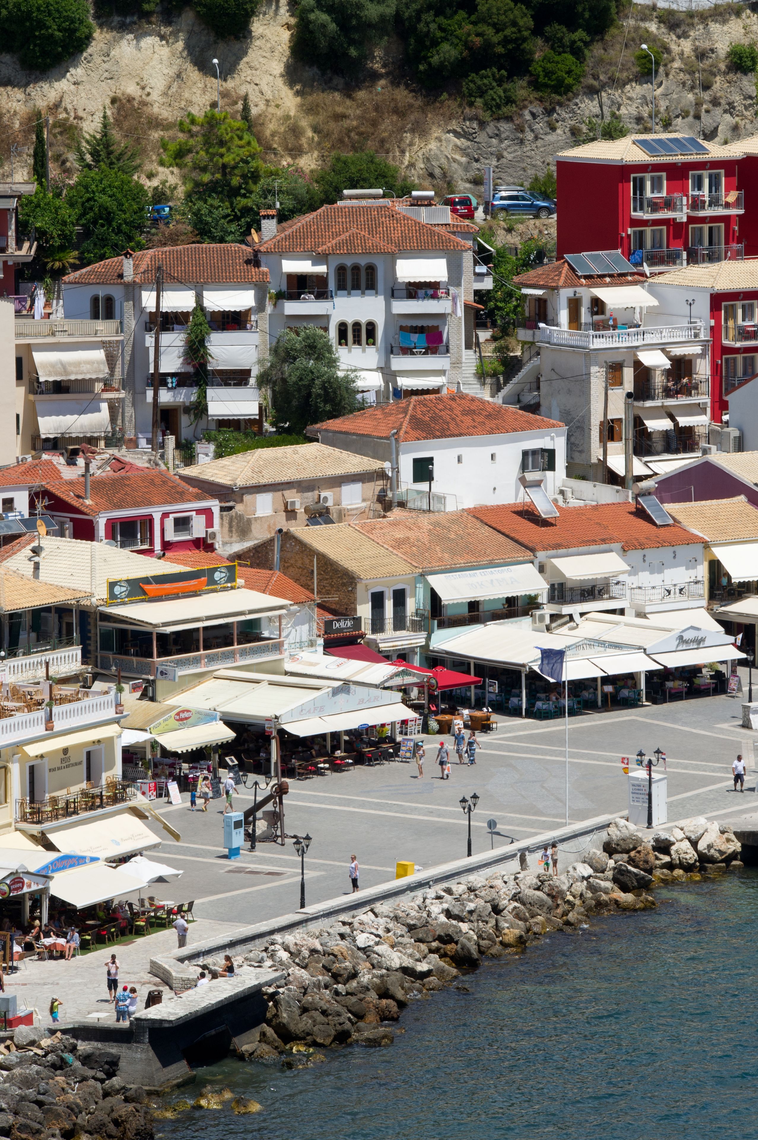 Uma cidade costeira com edifícios, um cais e costa rochosa.