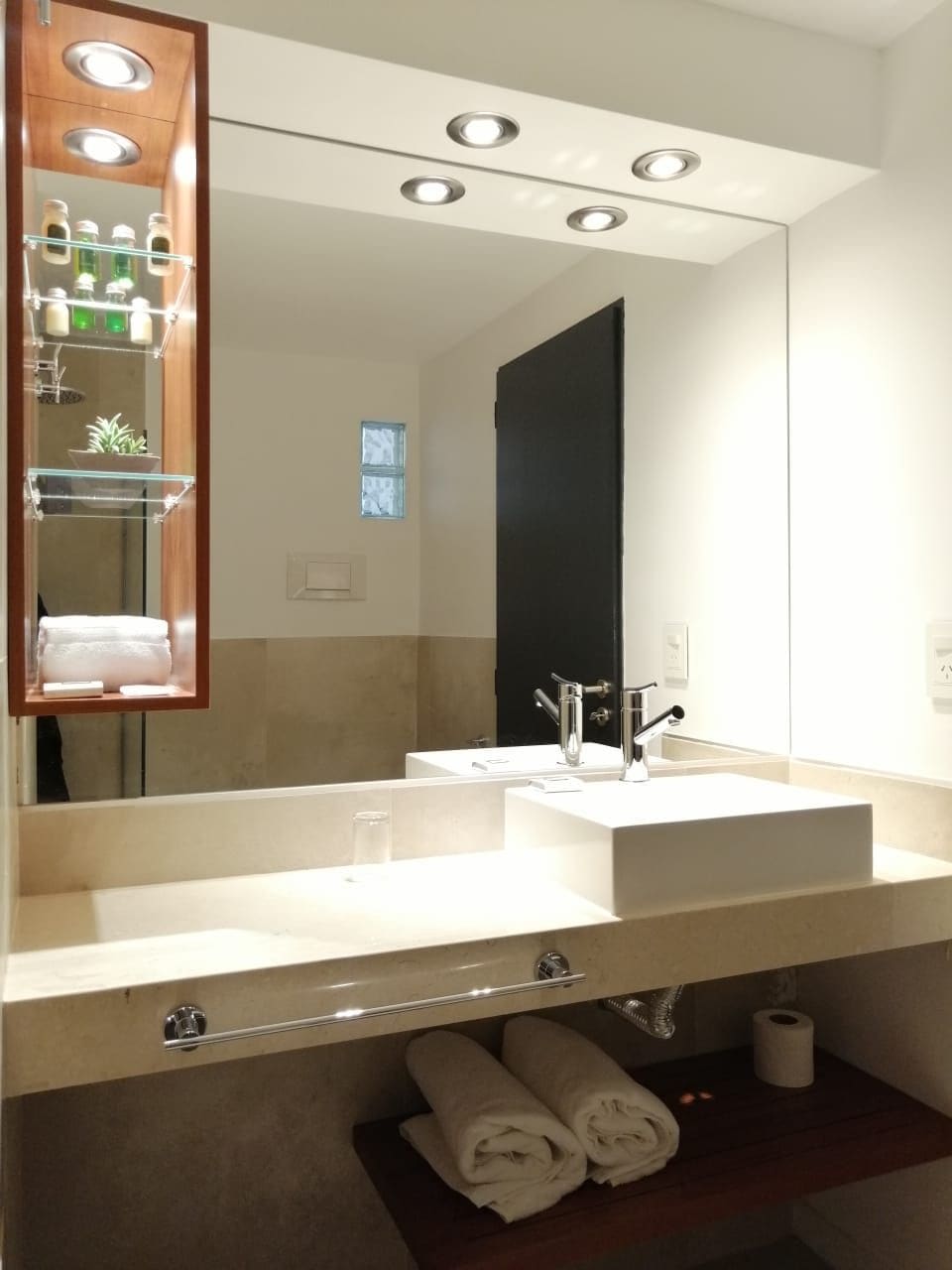 Casa de banho moderna com um espelho grande, duas pias e um porta-toalhas.