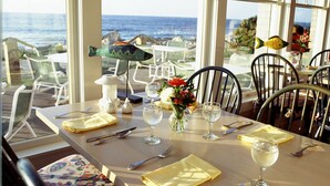 Mesa posta para refeição com vista para o mar.