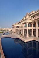 Um edifício grande e ornamentado, com várias colunas e uma piscina refletora.