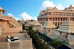 Um resort luxuoso com vários edifícios que exibem arquitetura tradicional, incluindo cúpulas e detalhes elaborados.