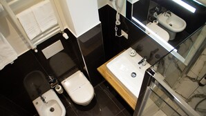 Uma casa de banho moderna com bidé, sanita e lavatório.