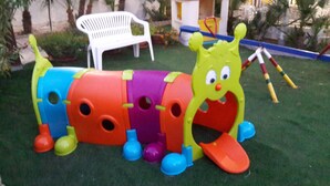 Um parquinho infantil com um trem e um brinquedo de dinossauro.