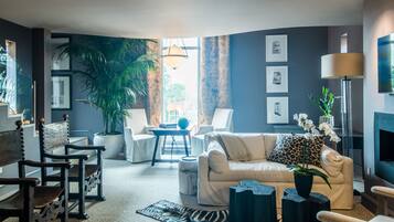 Uma sala de estar moderna com sofá, poltronas, mesa de centro e uma planta grande.