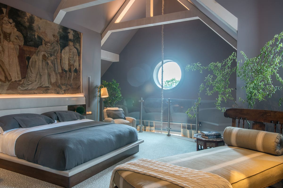 Quarto moderno com uma cama grande, um domo circular e um mural na parede.