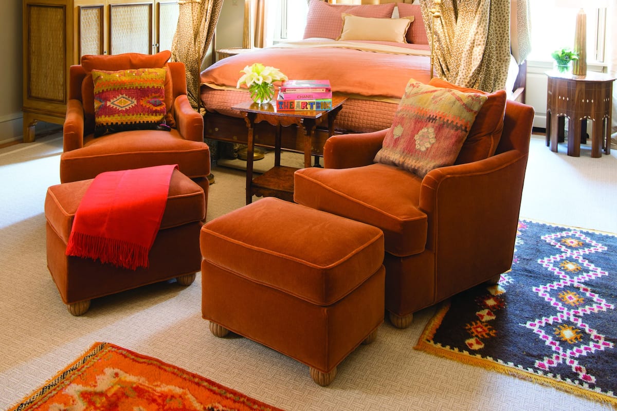 Um quarto espaçoso com uma cama de dossel, um candelabro e um guarda-roupa grande.