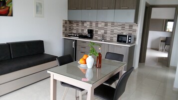 Apartamento executivo, vista para o mar | Cozinha americana privada | Cafeteira/chaleira, geladeira, micro-ondas, cooktop