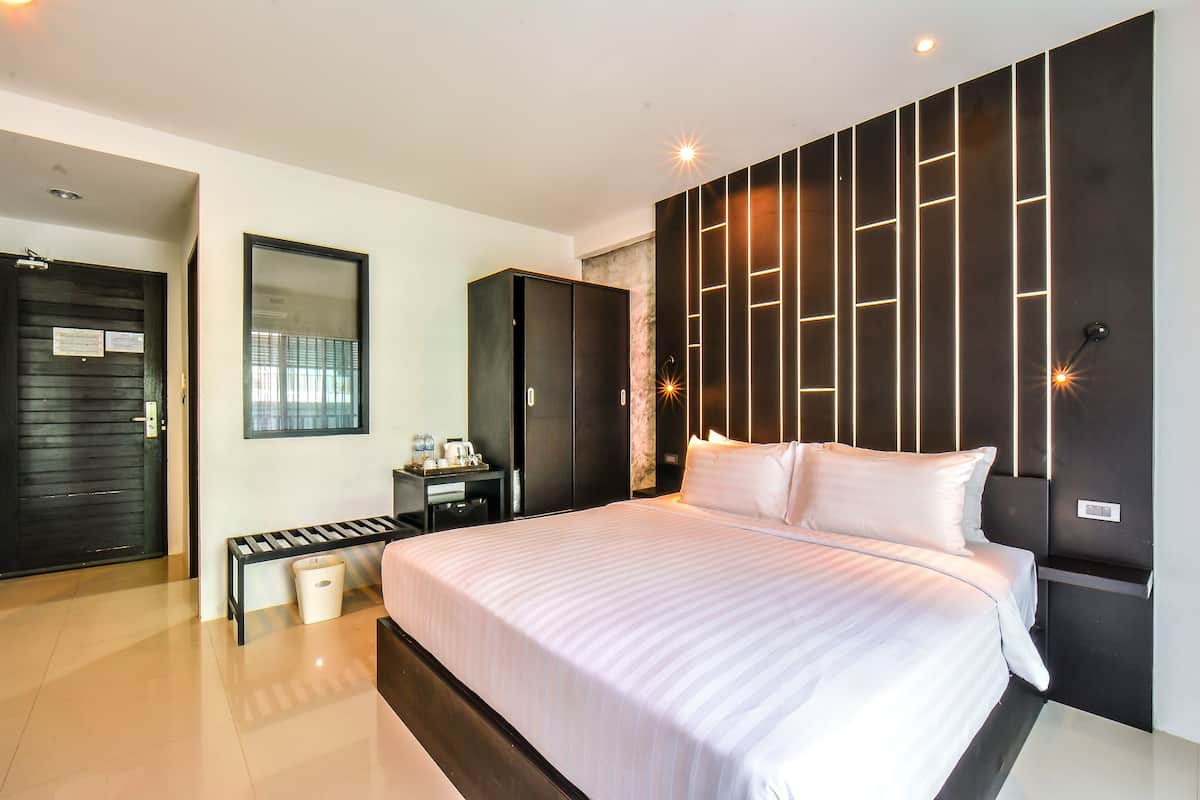 Quarto de hotel moderno com uma cama grande, uma escrivaninha e um guarda-roupa.
