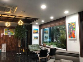 Um interior moderno com uma receção, área de estar e obras de arte nas paredes.