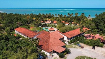Vista aérea de um resort com vários edifícios, uma piscina e uma praia.