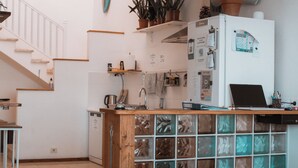 Uma cozinha com bancada de madeira, uma geladeira e uma pia.