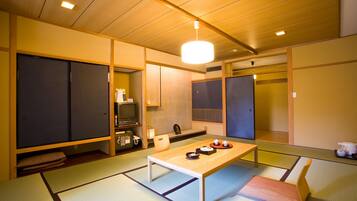 Um quarto japonês tradicional com piso de tatame, uma mesa baixa e portas deslizantes.