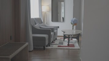 Uma sala de estar moderna com um sofá, uma mesa redonda pequena e um vaso decorativo.