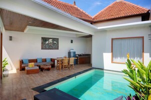 Uma casa moderna com piscina, área de refeições e cozinha.