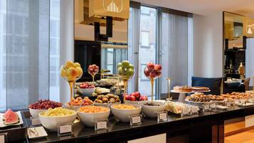 Um buffet com diversas frutas e doces.