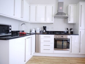 Apartamento, 2 quartos | Cozinha privada | Um frigorífico/congelador grande, um micro-ondas, uma placa de cozinha 