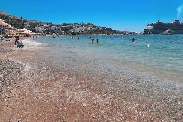 Uma praia privada, espreguiçadeiras, guarda-sóis de praia