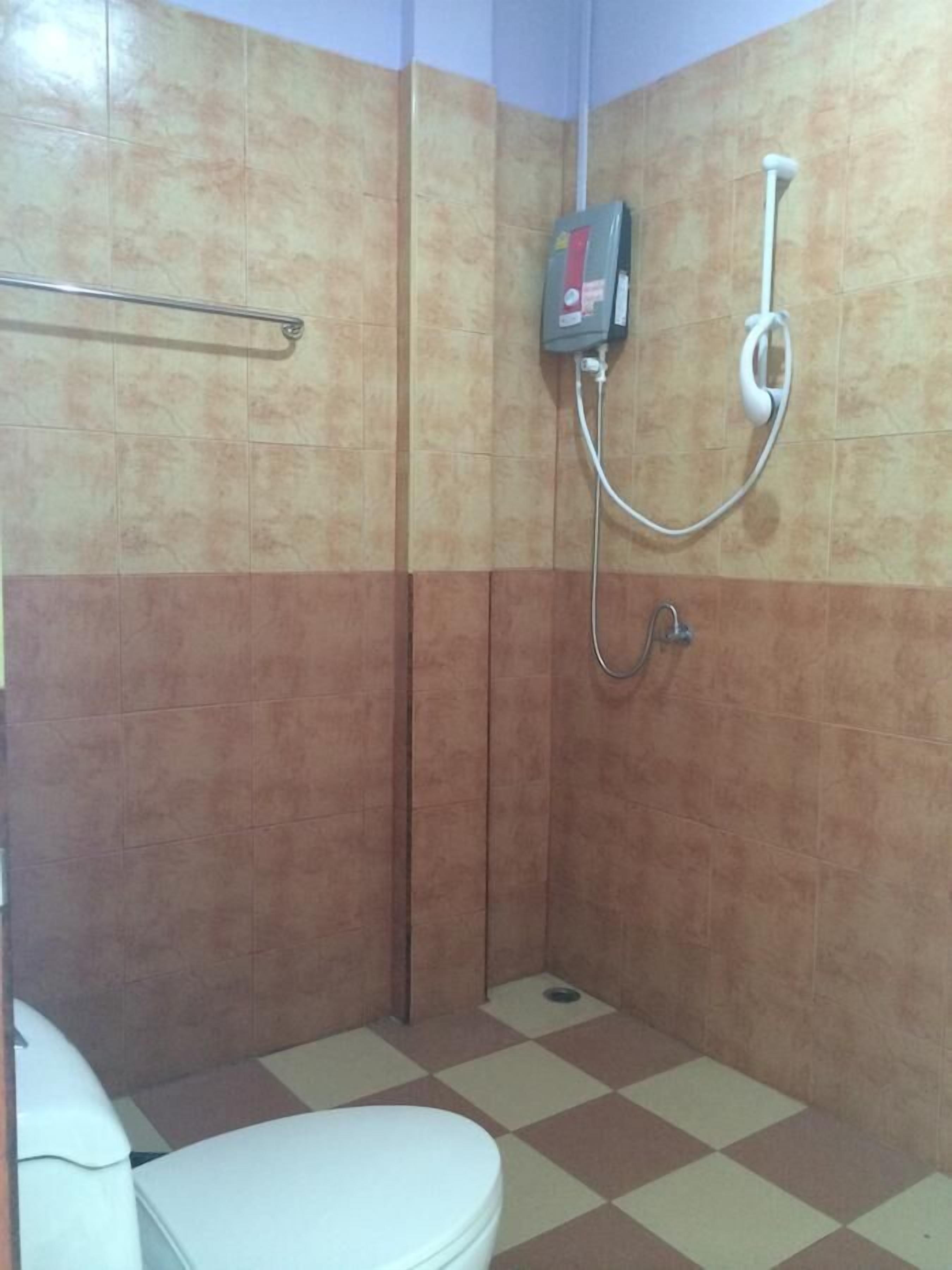 Um banheiro pequeno com azulejos, um vaso sanitário, um chuveiro e um porta-toalhas.