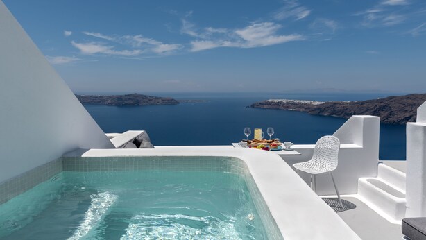 Uma piscina infinita moderna com vista clara para o mar e ilhas.