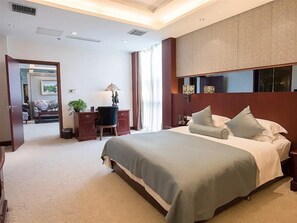 Quarto de hotel com uma cama grande, uma escrivaninha e vista para o corredor.