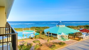 Um resort com piscina, um gazebo e vista para o mar.