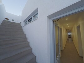Um edifício moderno com uma escadaria de concreto que leva a uma porta.