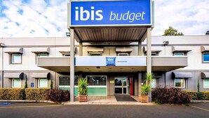 Um edifício moderno com uma placa que diz 'ibis budget'.