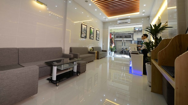 Um lobby moderno com um sofá, uma mesa de centro e um balcão de recepção.