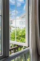 Uma janela com vista para um edifício e vegetação.
