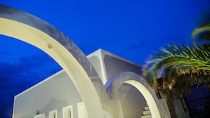 Um edifício moderno com elementos arquitetônicos curvos e um céu claro.