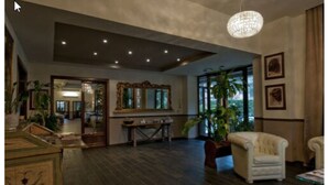 Um quarto amplo com um espelho grande, um candelabro e um armário de madeira.