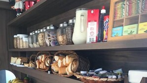 Disposição de buffet com diversos alimentos e acompanhamentos em prateleiras e balcões.